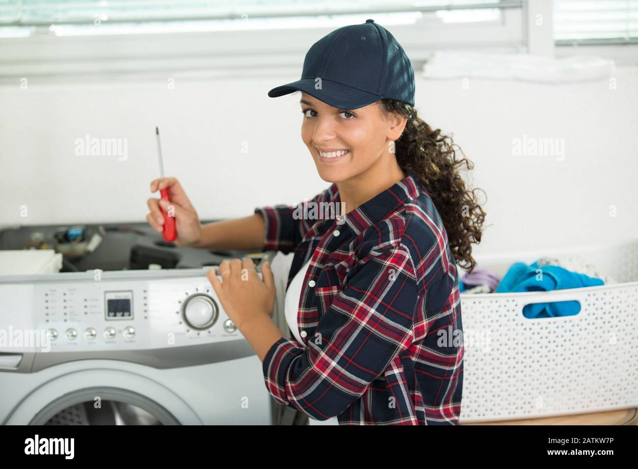 young woman with screwdriver repairing washing machine Stock Photo - Alamy