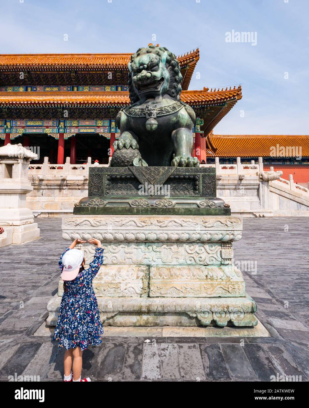 Young child looking at bronze guardian lion, Gate of Supreme Harmony ...