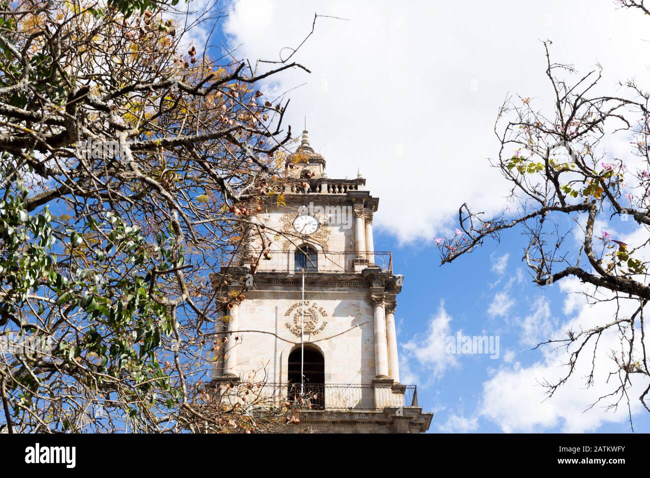 old stone tower with clock surrounded by trees in autumn in Guatemala ...