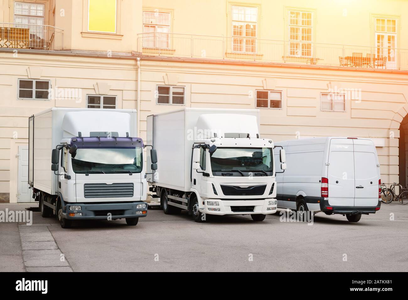 Different small and medium courier service trucks and van at building ...