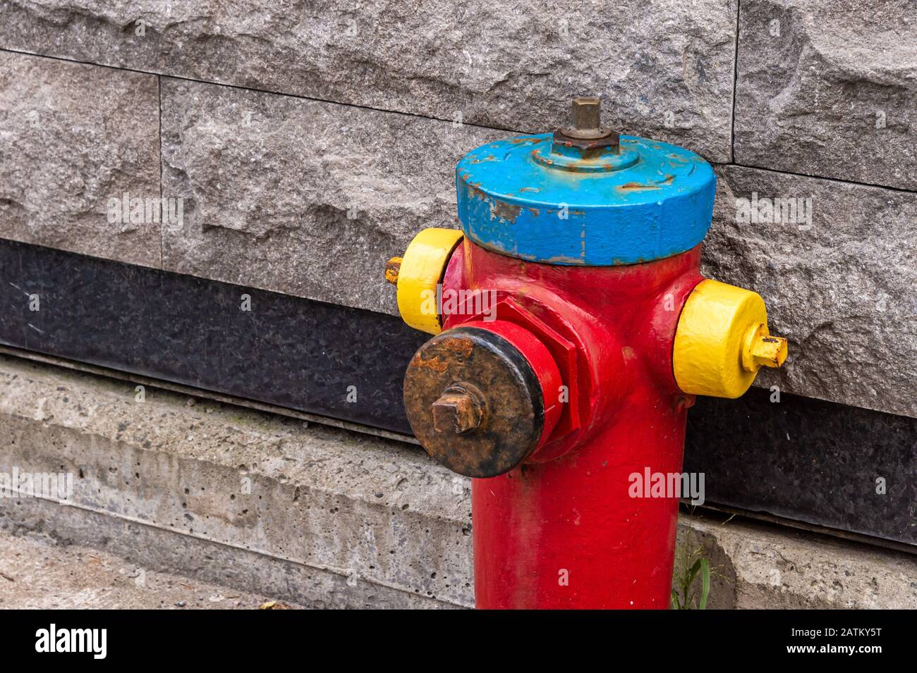 Red, blue & yellow fire hydrant Stock Photo - Alamy