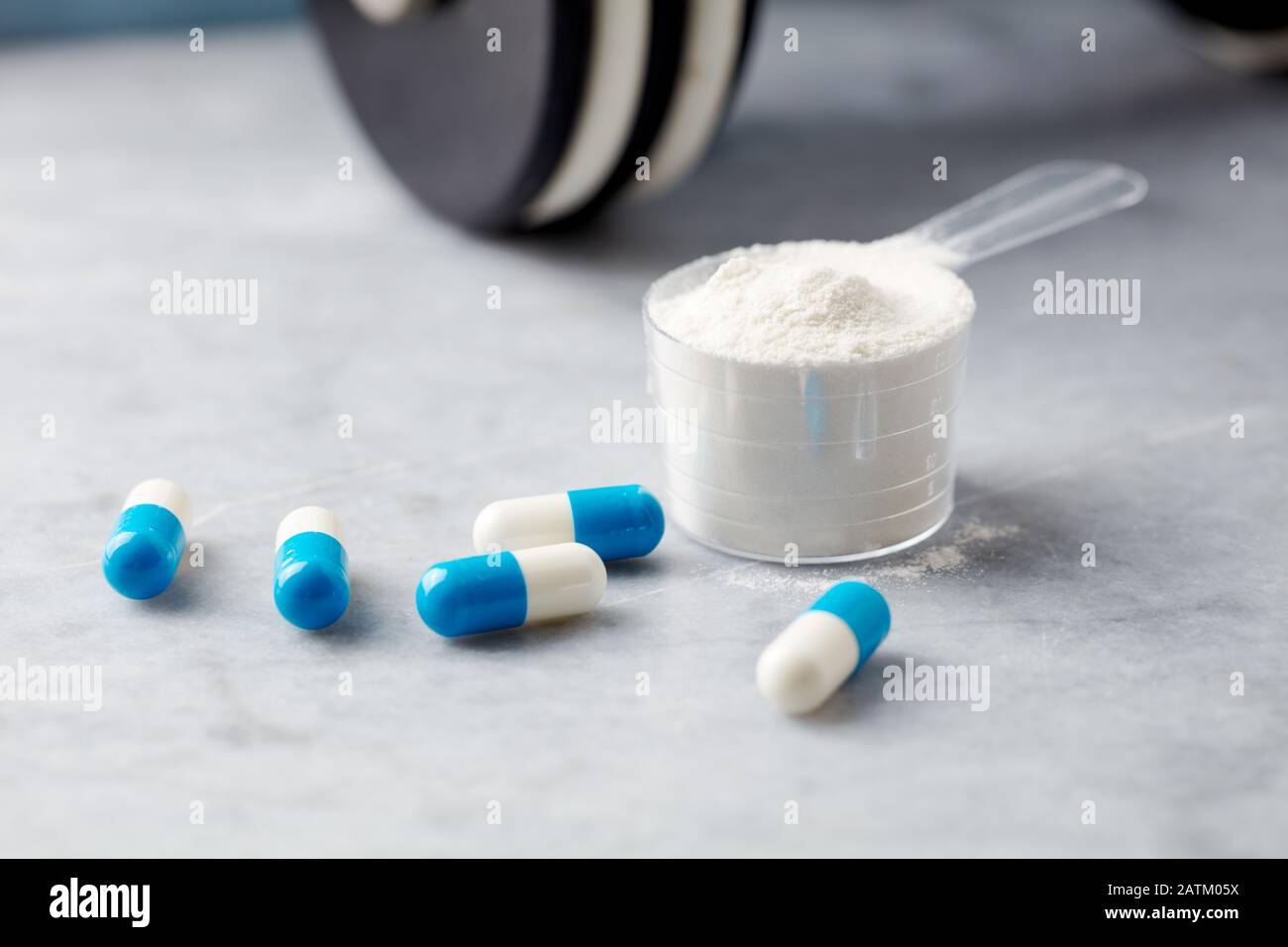 Scoop of Whey Protein, creatine capsules and a dumbbell. Bodybuilding ...