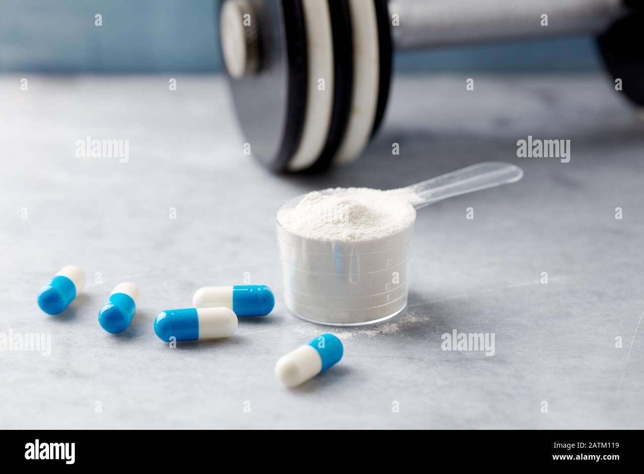 Scoop of Whey Protein, creatine capsules and a dumbbell. Bodybuilding ...