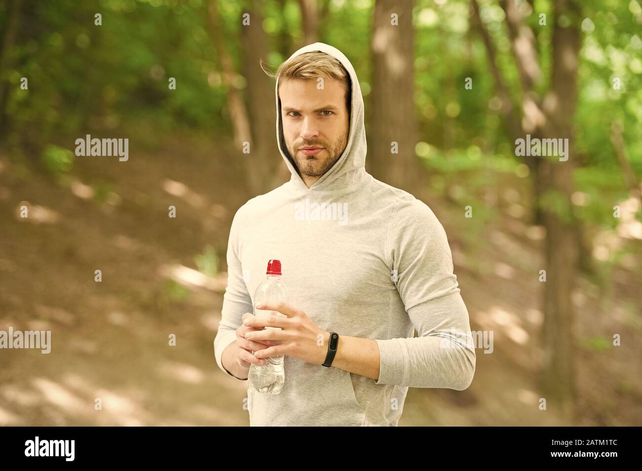 Stay hydrated. Athlete drink water after training in park. Vitamins and ...