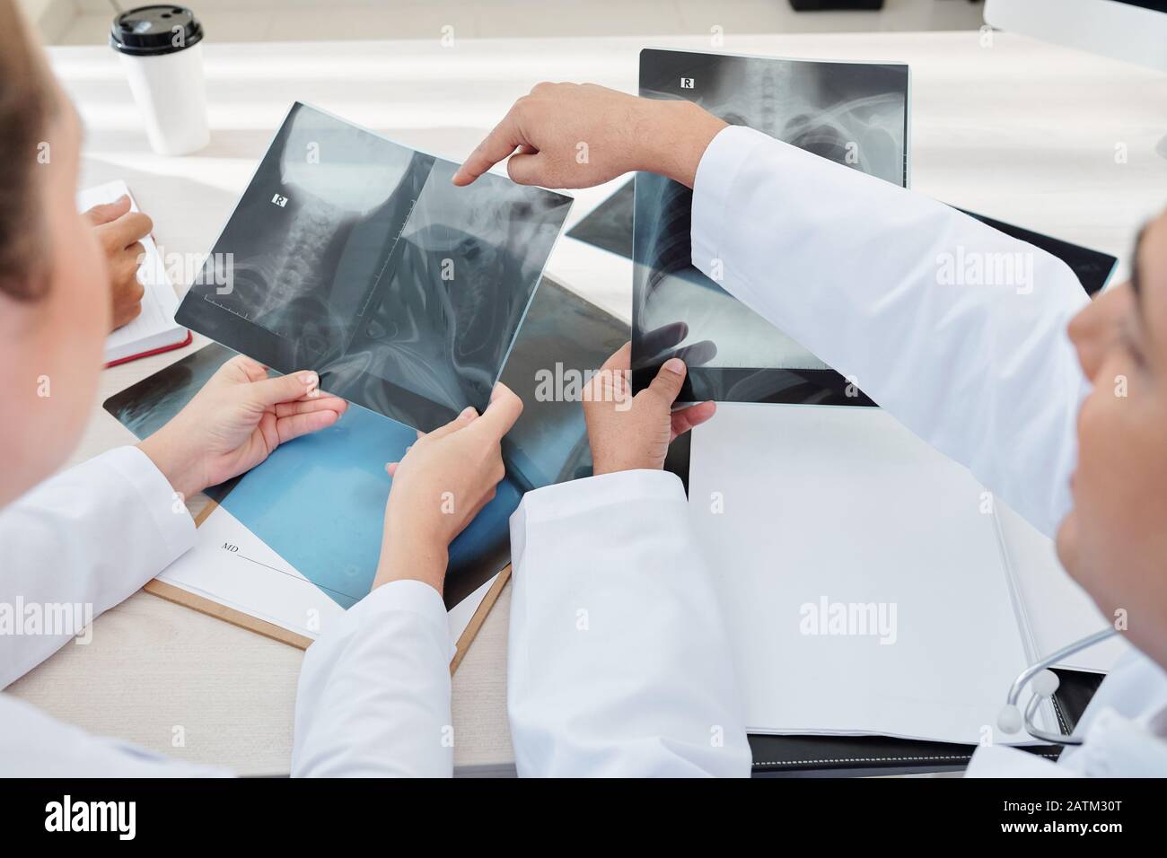 Close-up image of healthcare workers discussing chest and throat x-rays ...