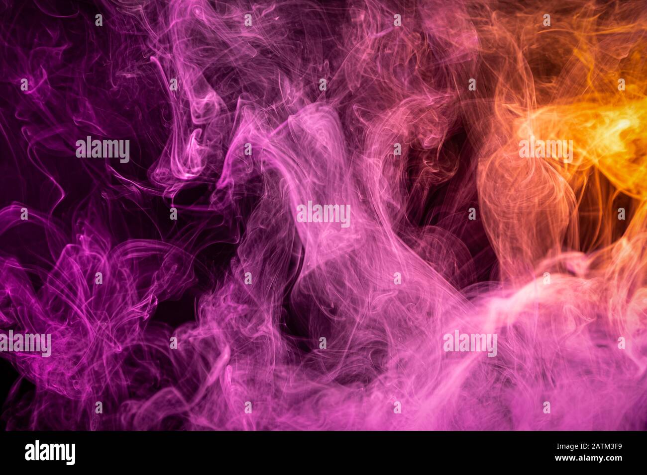 Dense multicolored smoke of pink and red colors on a black isolated ...