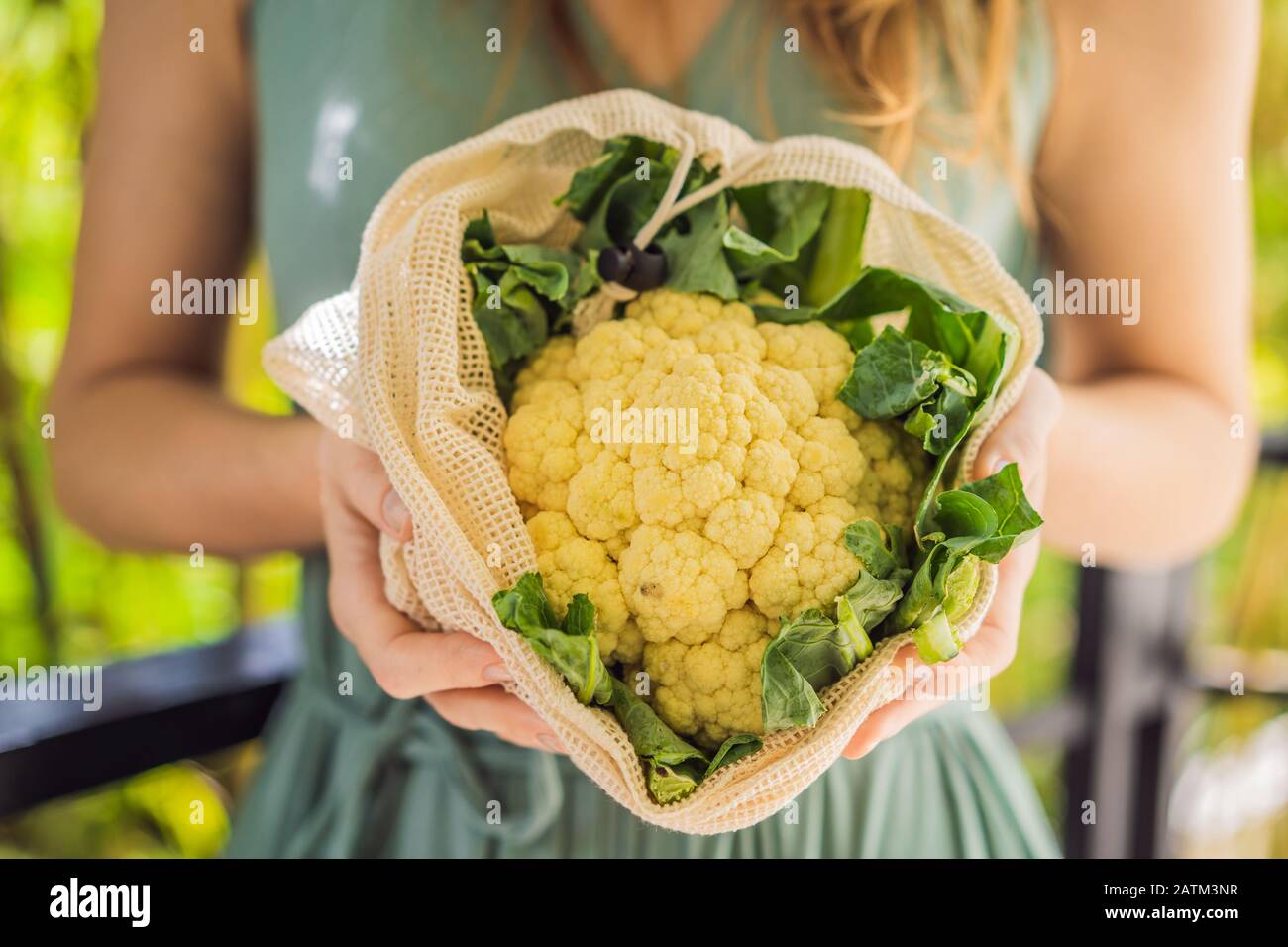 Cauliflower in a reusable bag in the hands of a young woman. Zero waste ...
