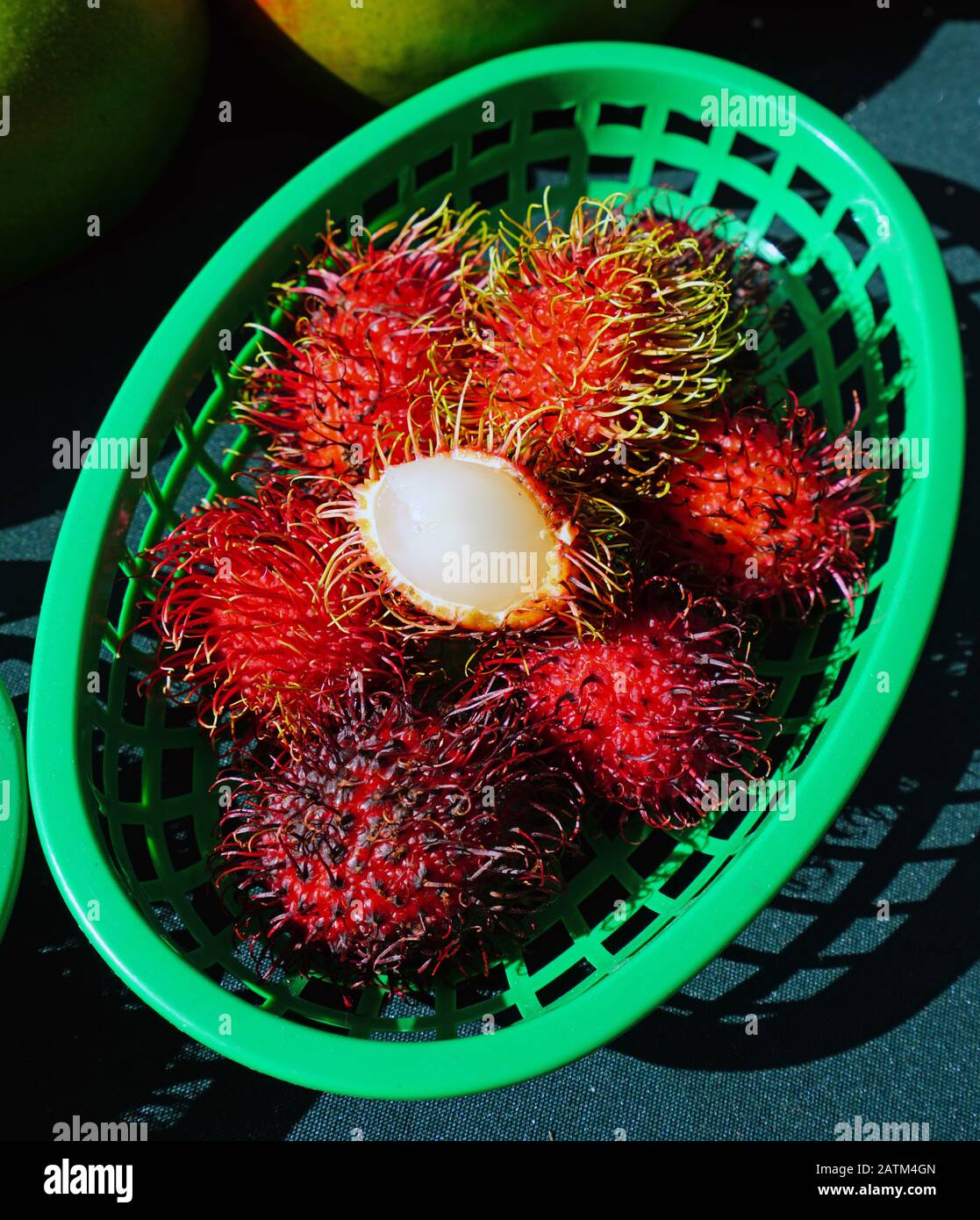Green baskets of spiky red rambutan fruit at a market Stock Photo - Alamy