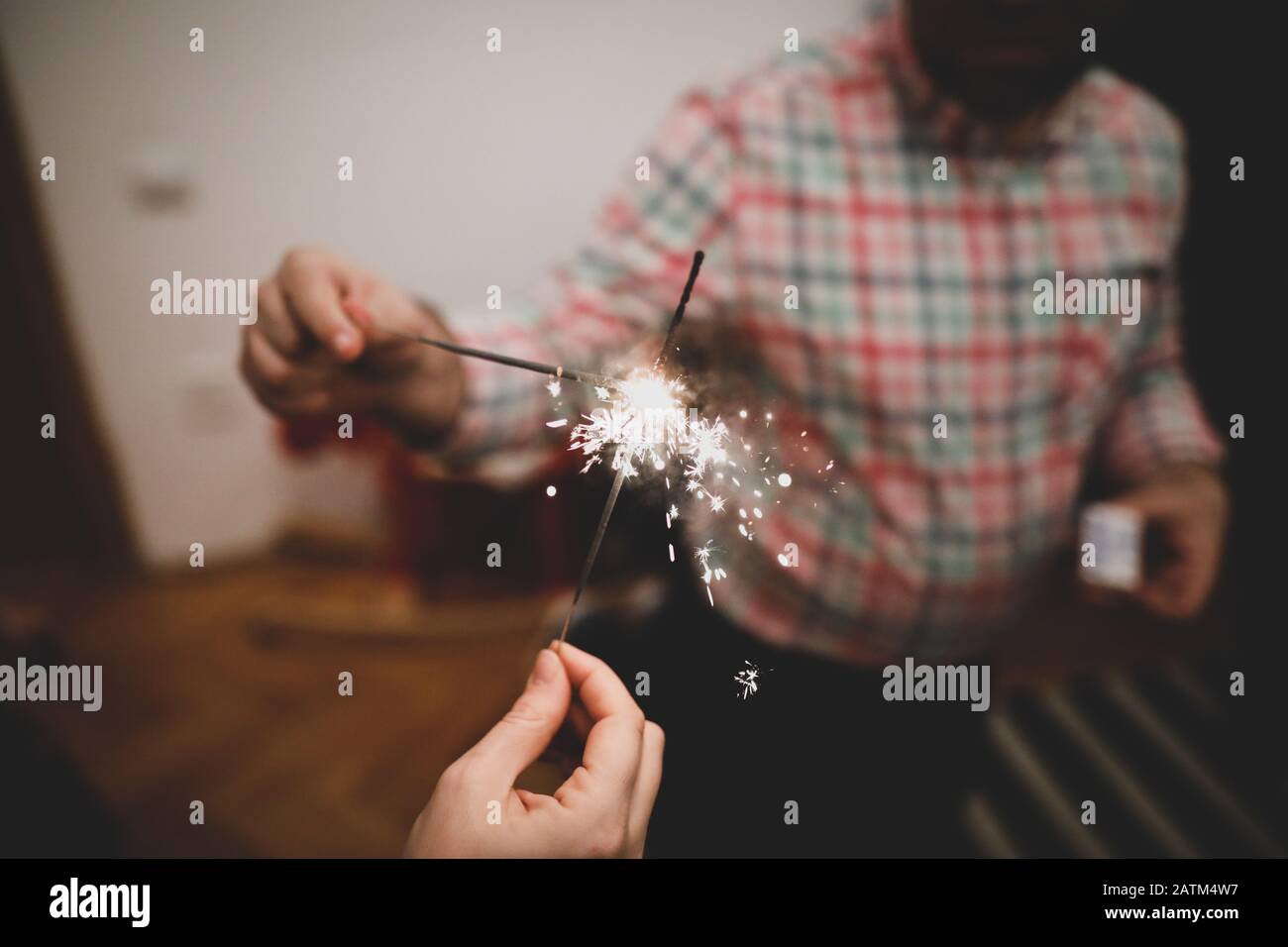 Details with the hands of a couple holding sparklers hand fireworks ...