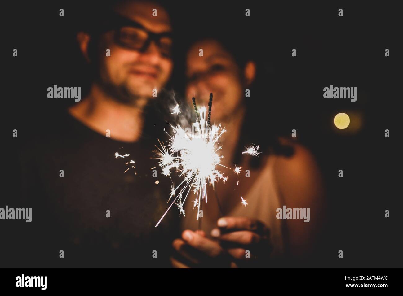 Details with the hands of a couple holding sparklers hand fireworks ...