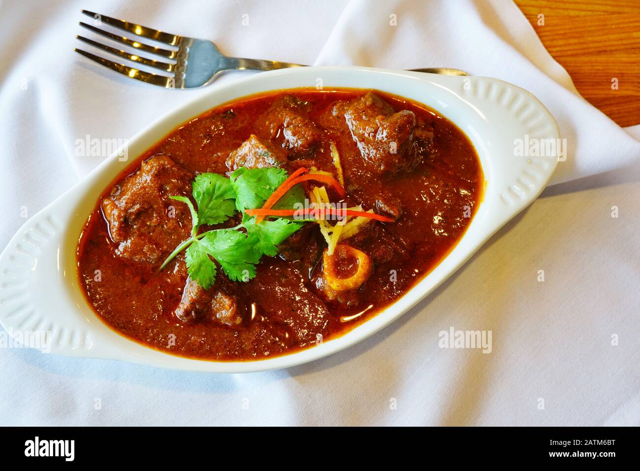 A dish of red goat curry at an Indian restaurant Stock Photo - Alamy
