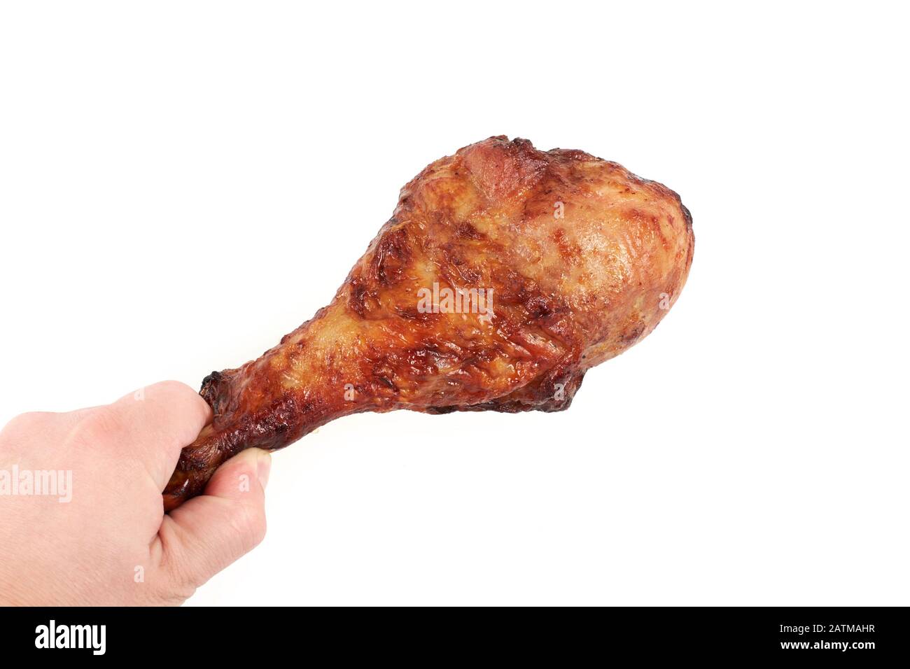 Close up and isolated image of hand holding a grilled chicken leg on ...