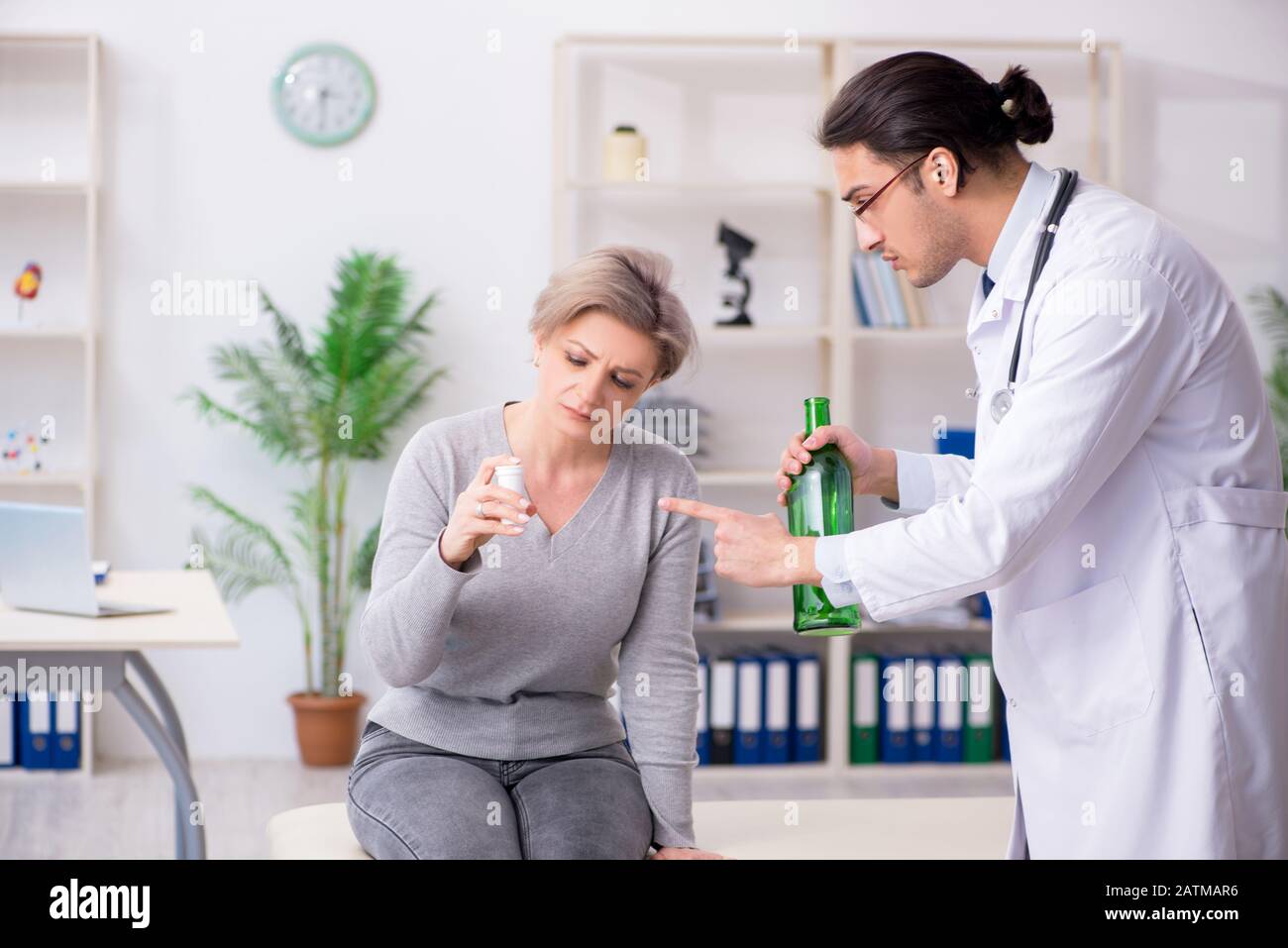 The female alcoholic visiting young male doctor Stock Photo - Alamy