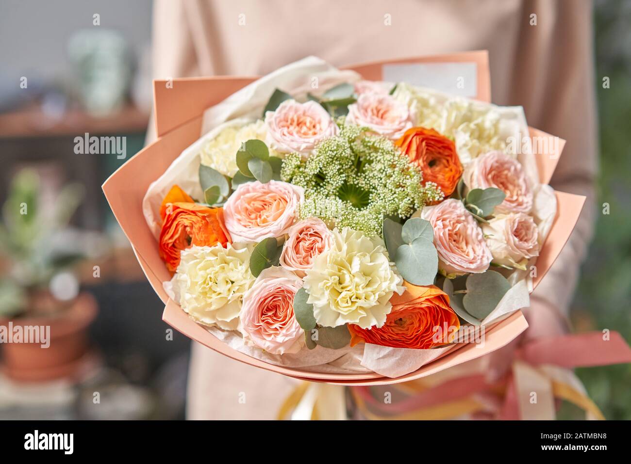 European floral shop. Beautiful bouquet of mixed flowers in womans ...