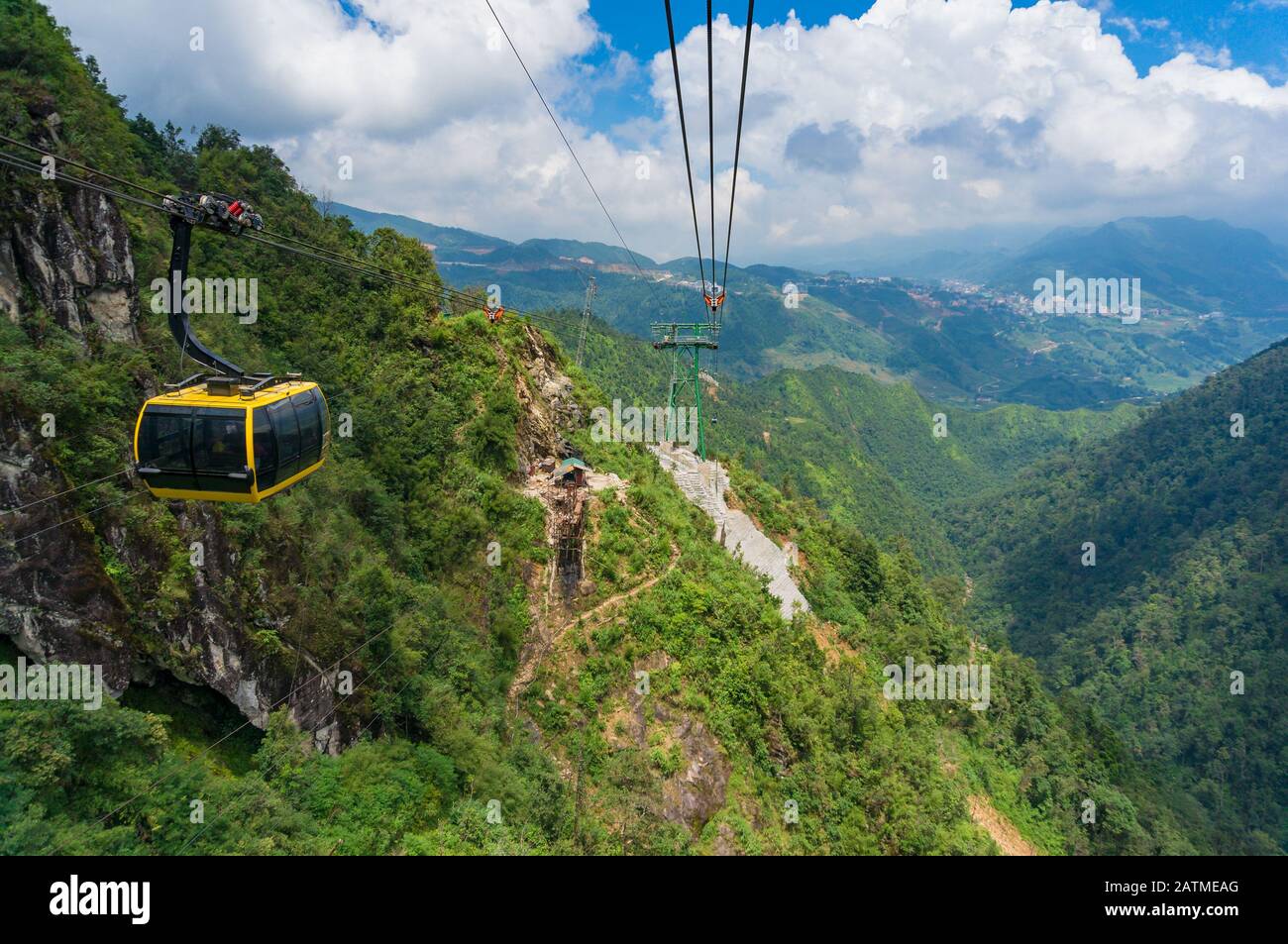 Cable car riding over mountain slope covered with forest. Travel ...
