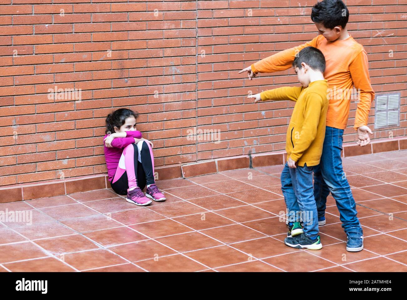 Two boys making bullying to a girl Stock Photo - Alamy