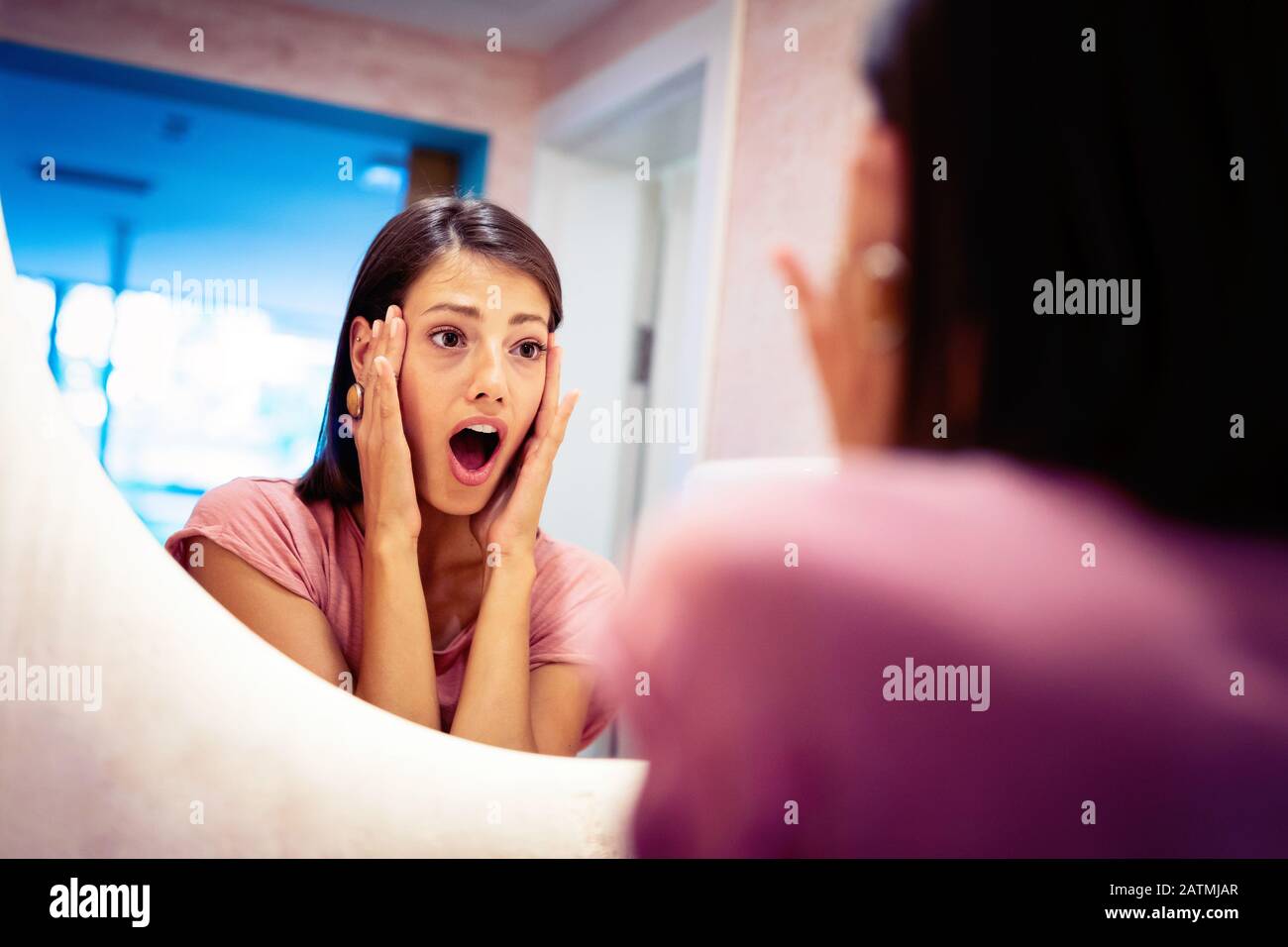 Mirror reflection of a woman worrying because of wrinkles on her ...