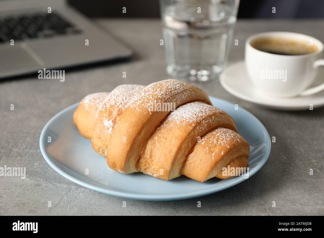 Composition with croissant and computer on grey table, close up Stock ...