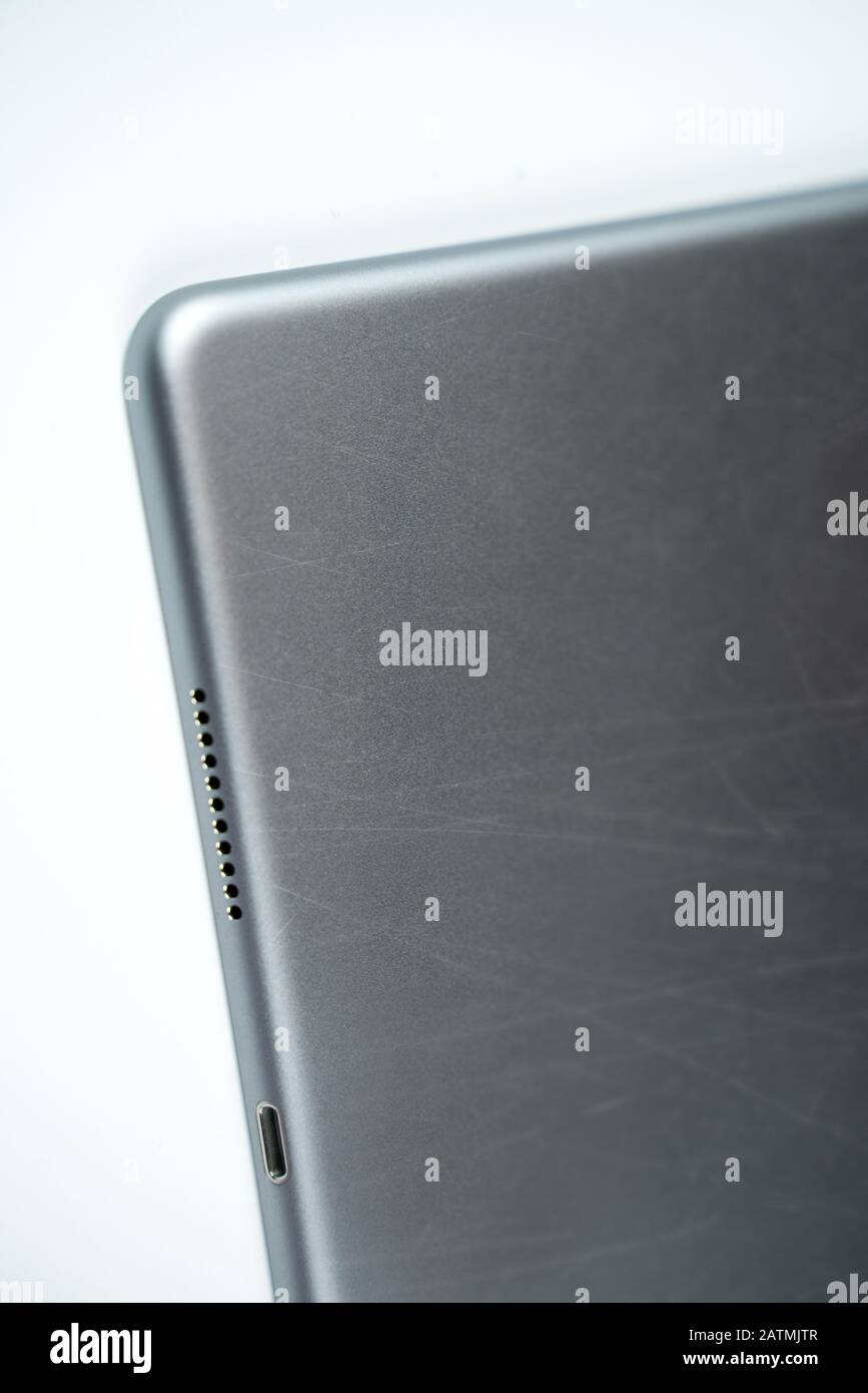 Scratched back side of tablet isolated on white background, speaker ...