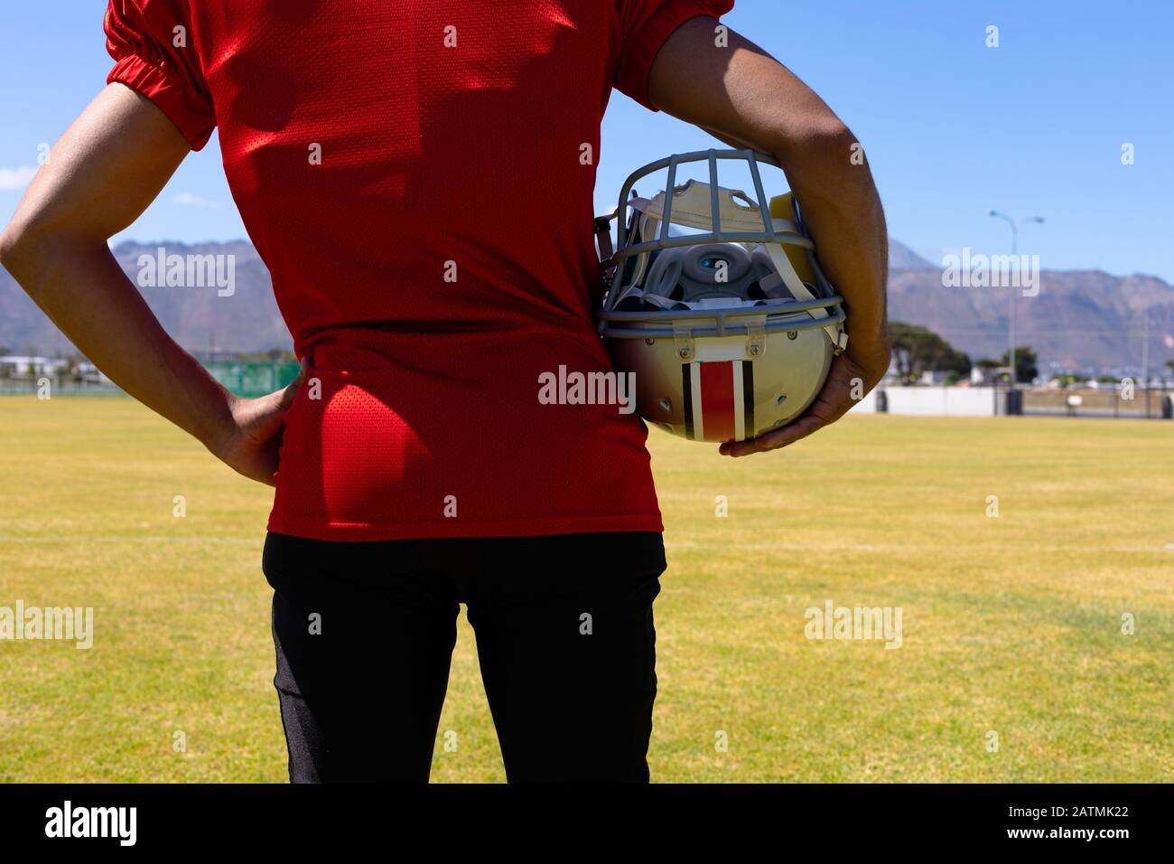 Football player carrying his helmet Stock Photo - Alamy