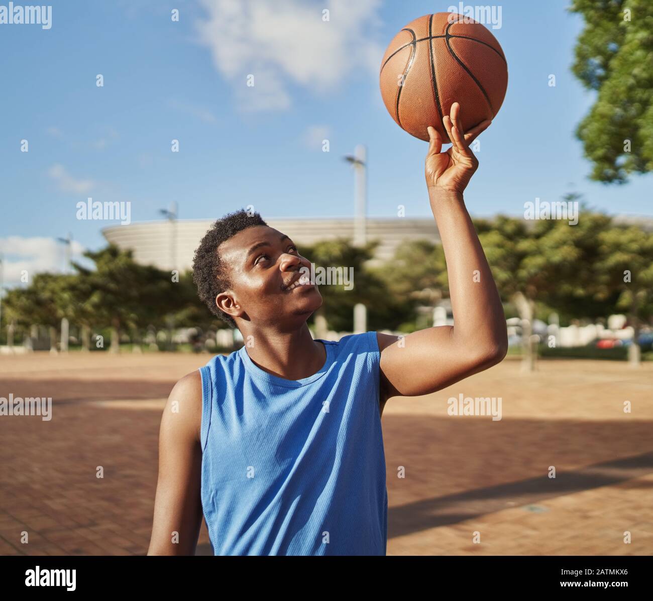 Portrait of a african american basketball player balancing his ball on ...