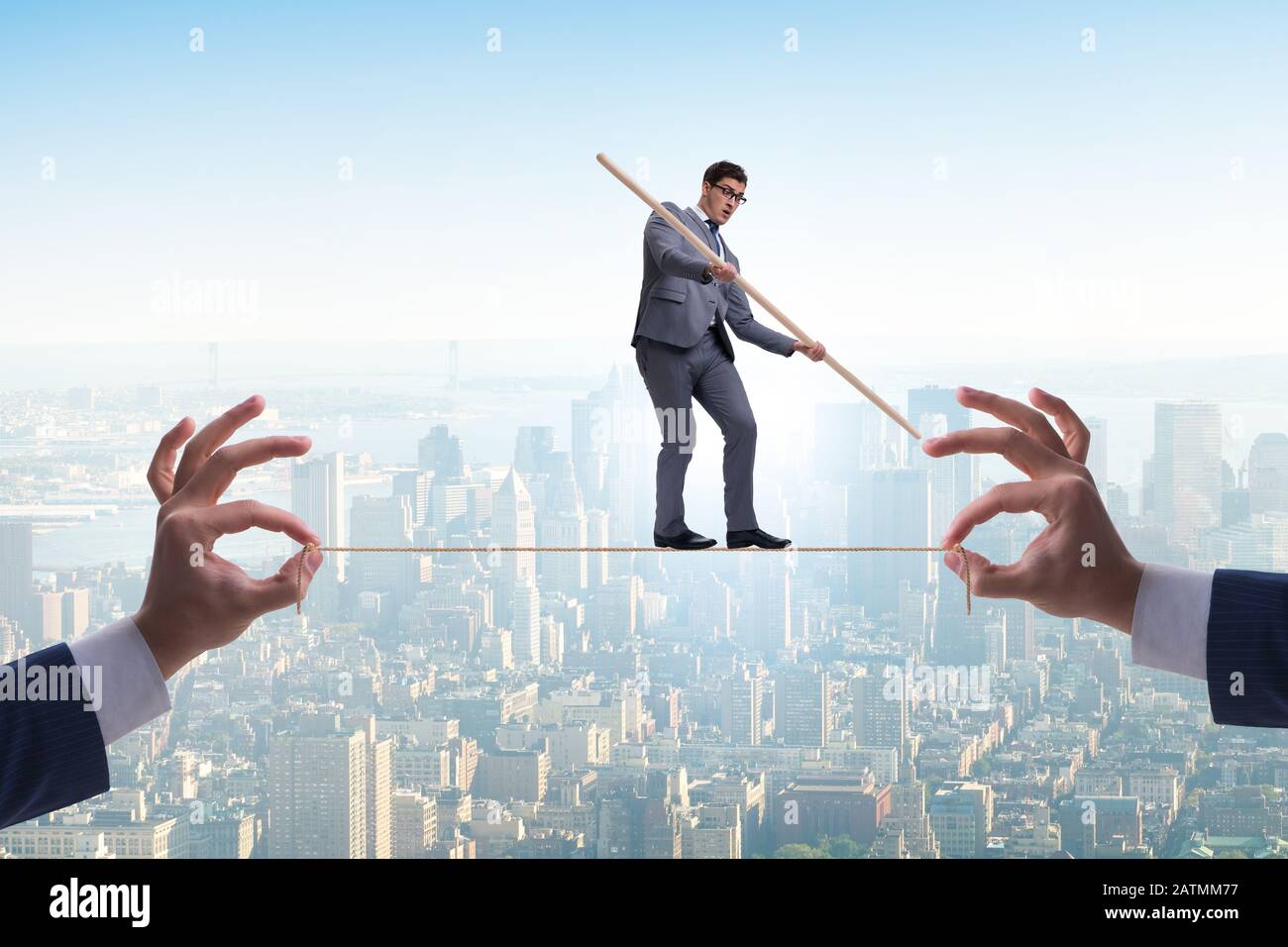 The businessman walking on tight rope Stock Photo - Alamy