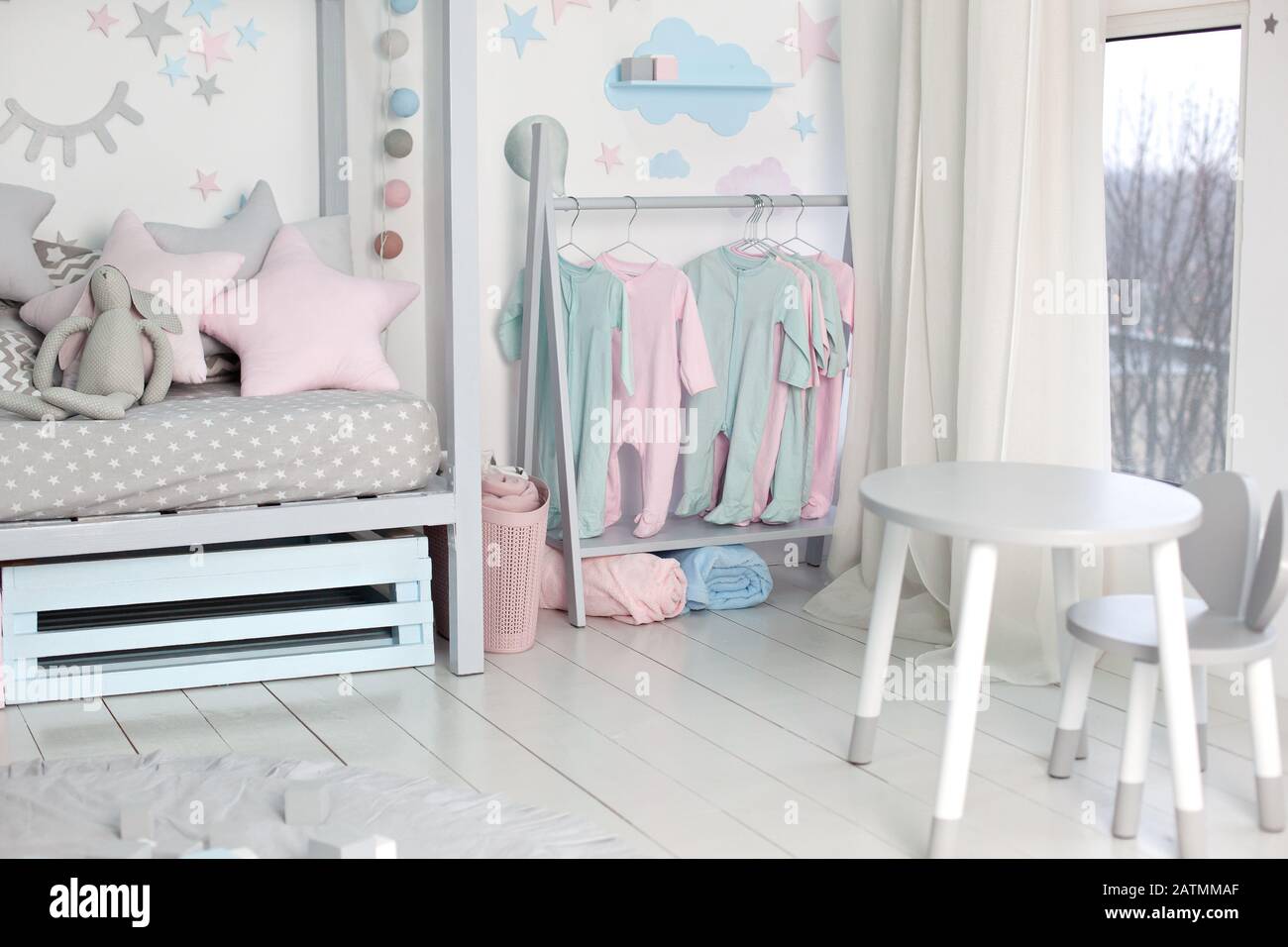 Clothes for little child hung in children room. Rack with hangers with ...