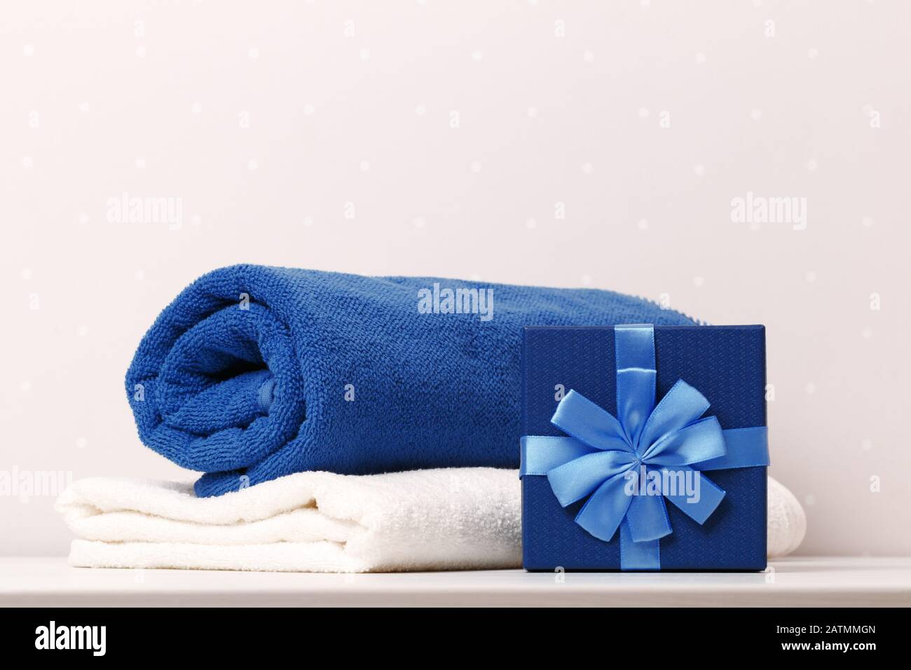 Close-up of a box with a gift of blue and white towels on a table ...