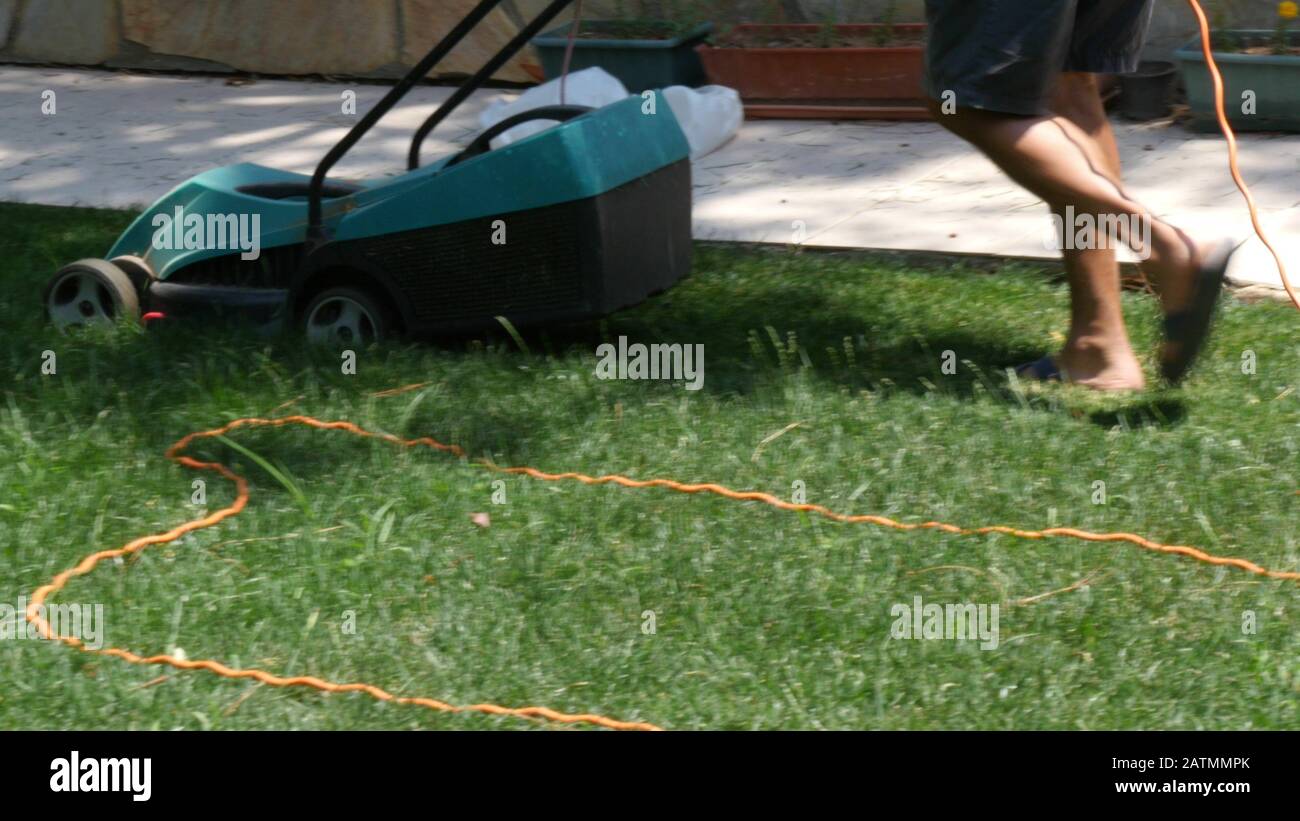 Lawn mower cutting the grass. Gardening activity Stock Photo - Alamy