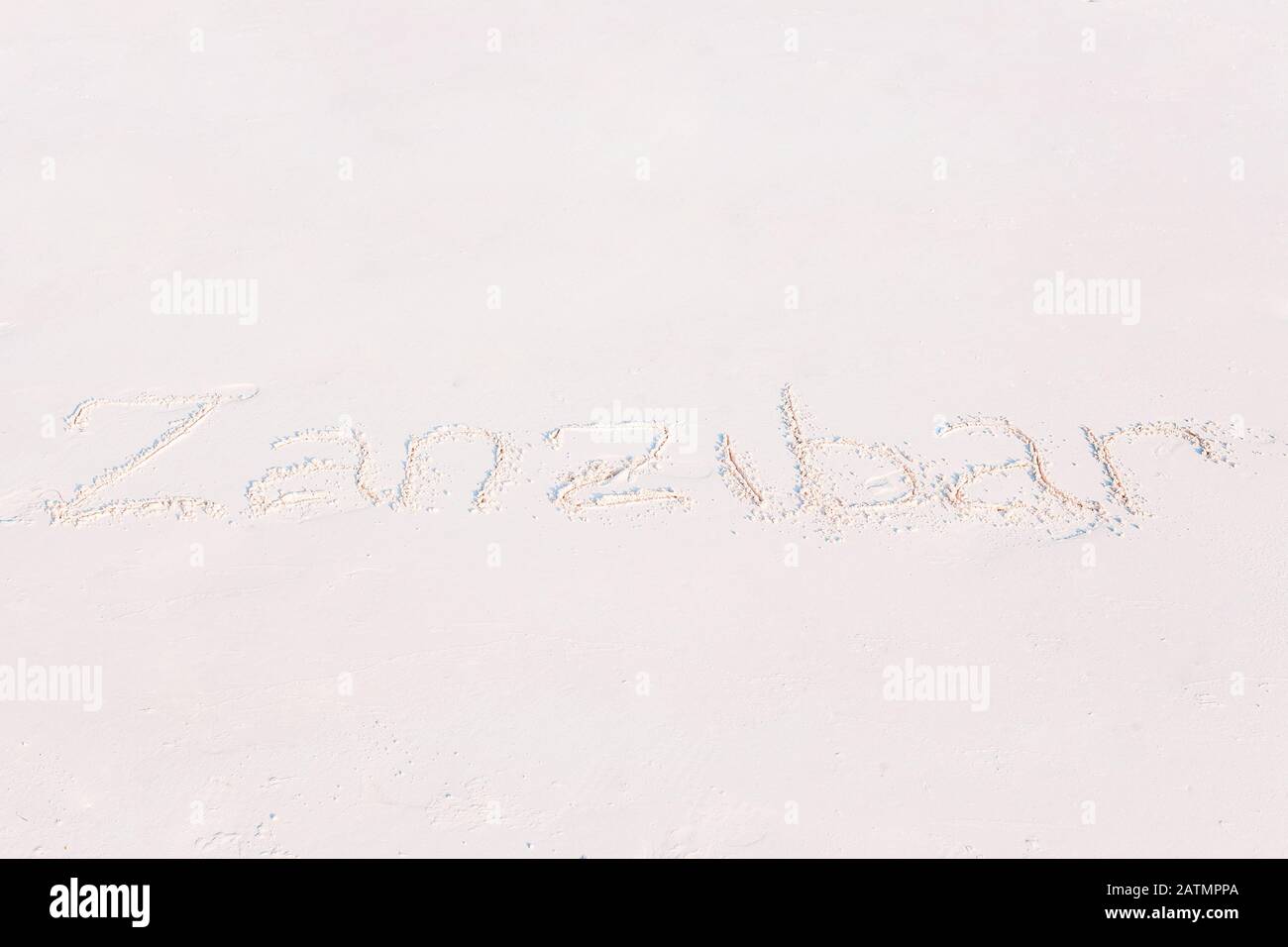 Word Zanzibar handwritten on sand beach with soft ocean wave on ...