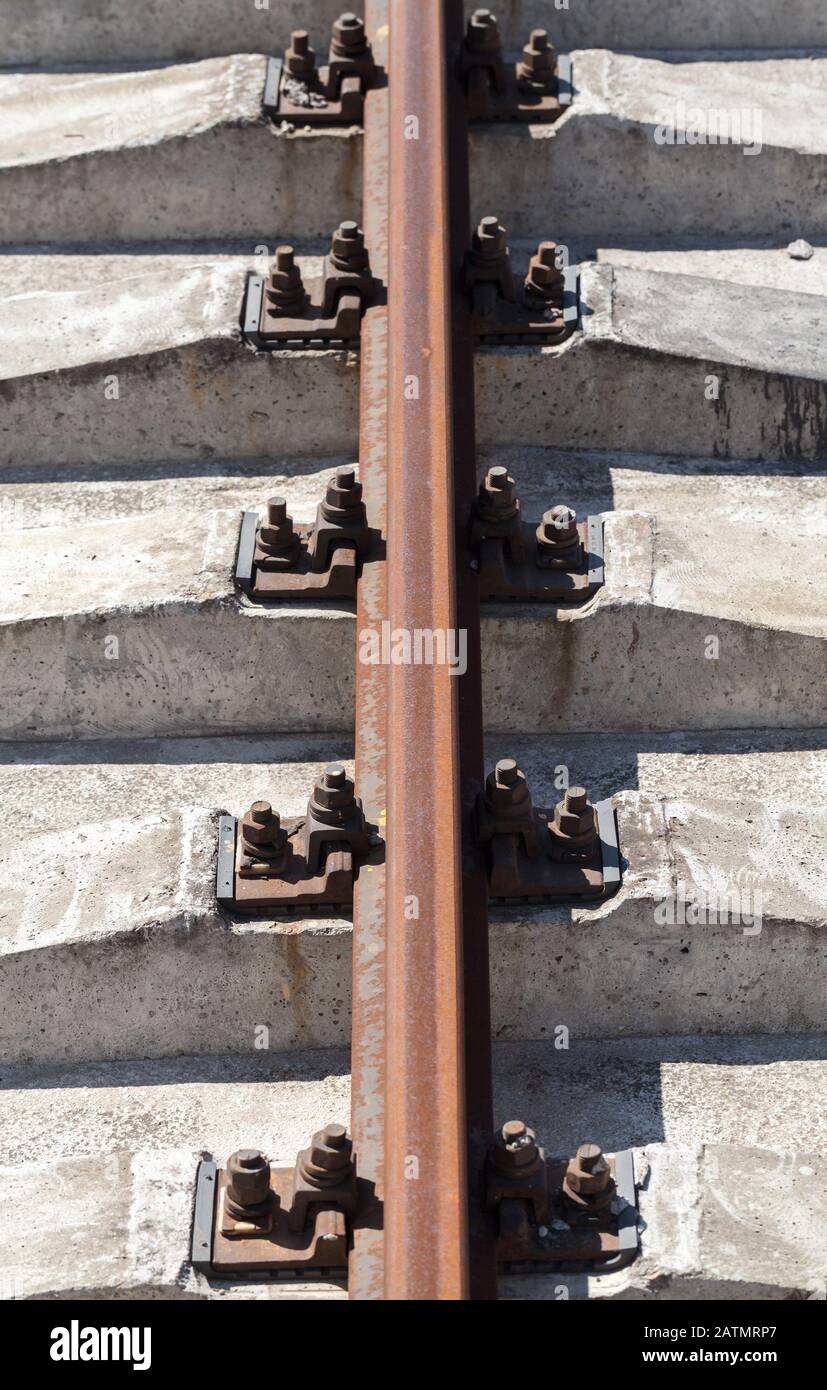Rusty rail on concrete sleepers. Vertical photo background Stock Photo ...