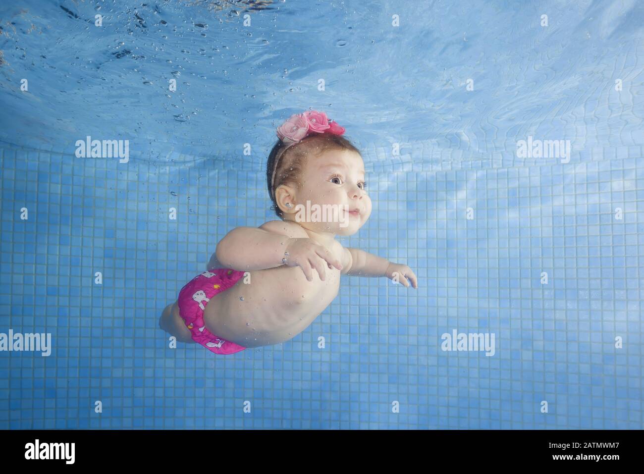 Little baby learning to swim underwater in a swimming pool hi-res stock ...