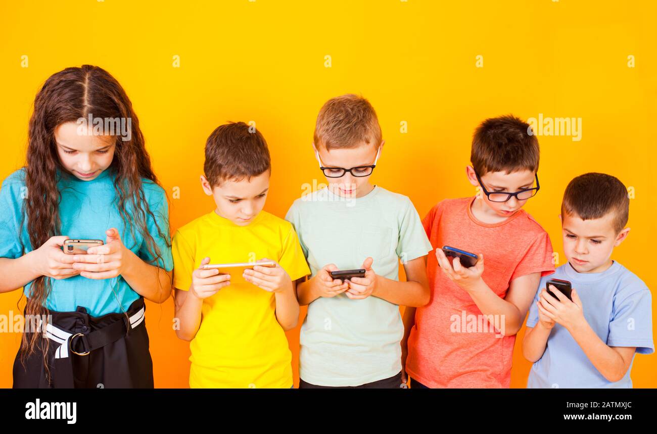 Group of kids using digital mobile phone Stock Photo - Alamy