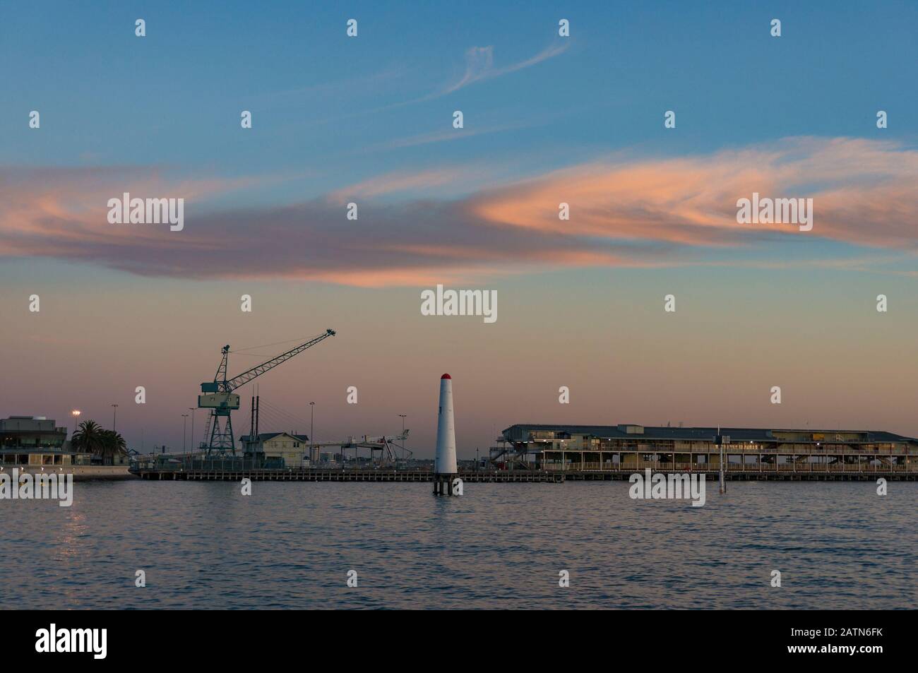 Wharf with hoisting crane and lighthouse at dusk. Nautical, sea port ...