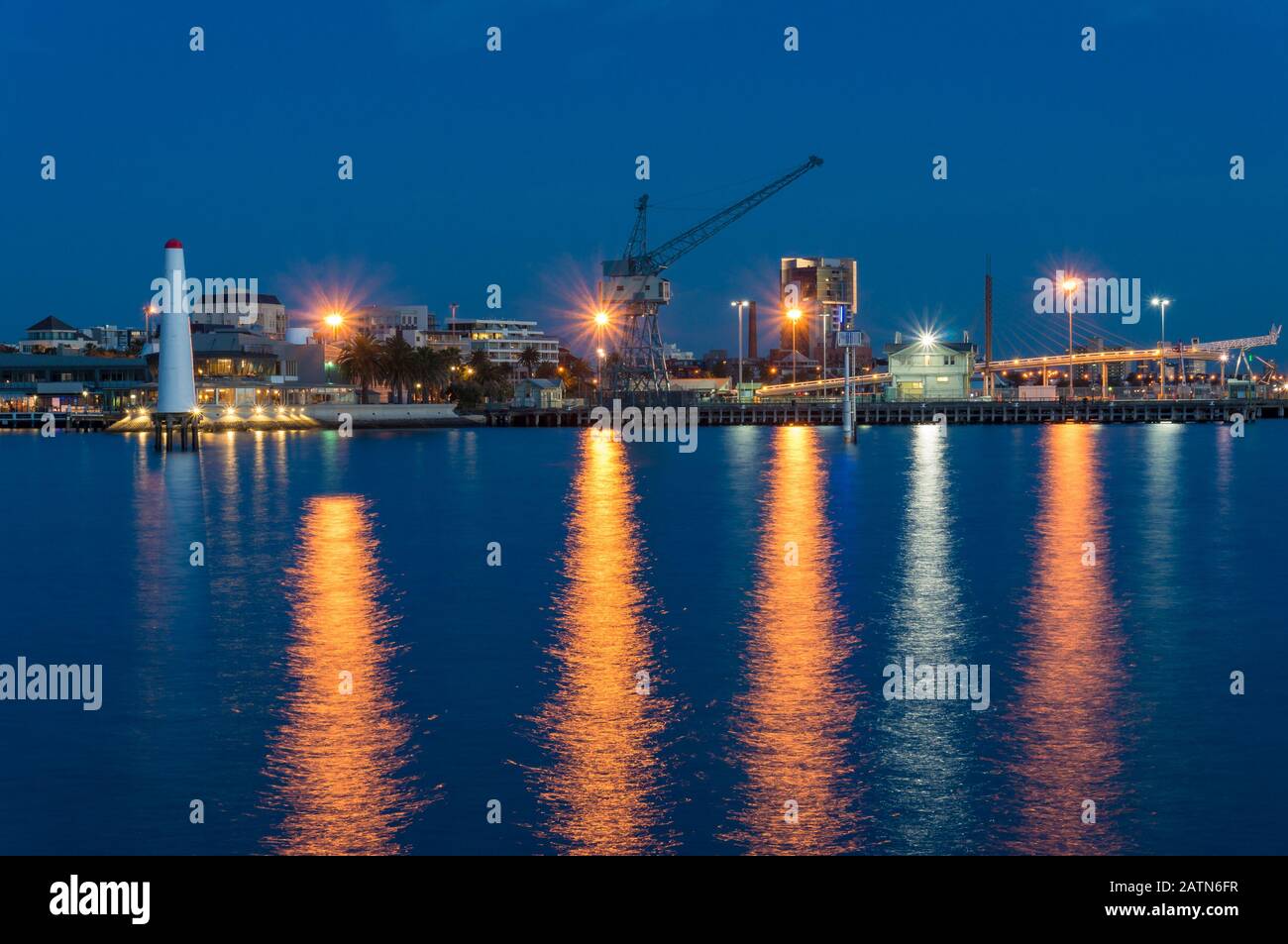 Wharf with crane, machinery and lighthouse at night. Nautical, sea port ...