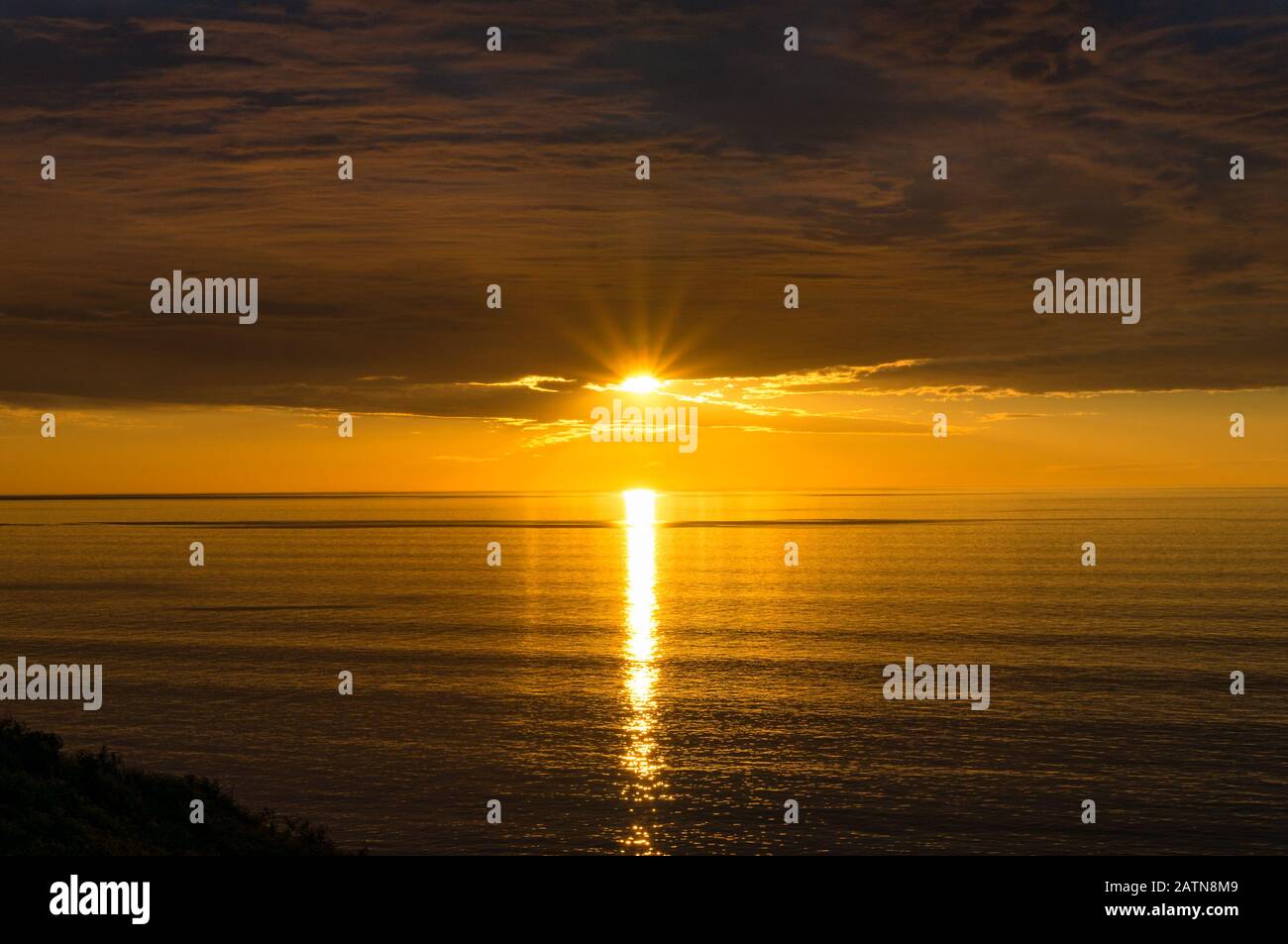 Spectacular sunset over sea with vivd golden colores of water and sky ...