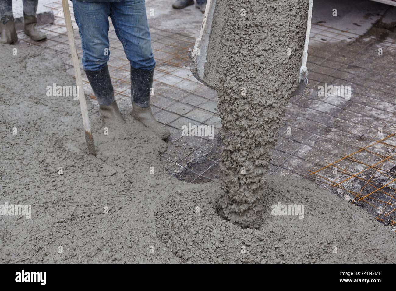workers pouring wet concrete using concrete bucket. Industrial ...