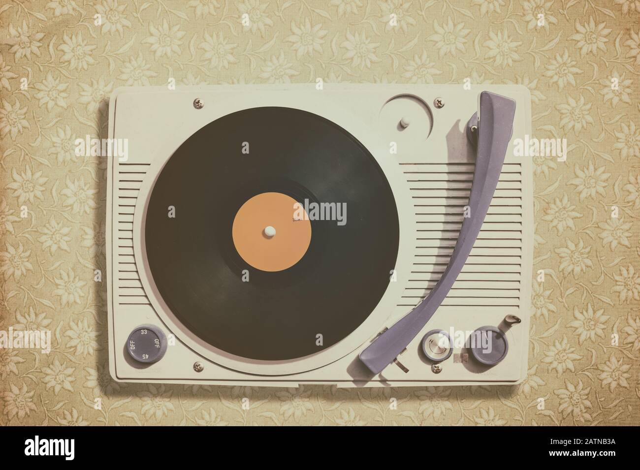 Retro styled image of an old record player on top of flower wallpaper ...