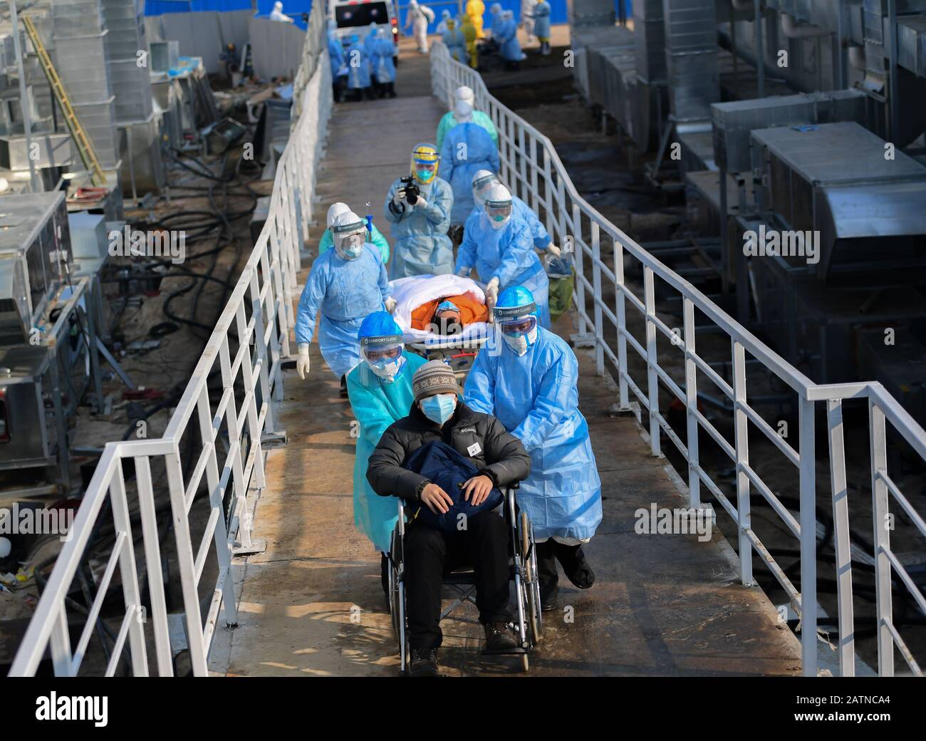 Chinese medical workers escort the first batch of patients infected ...