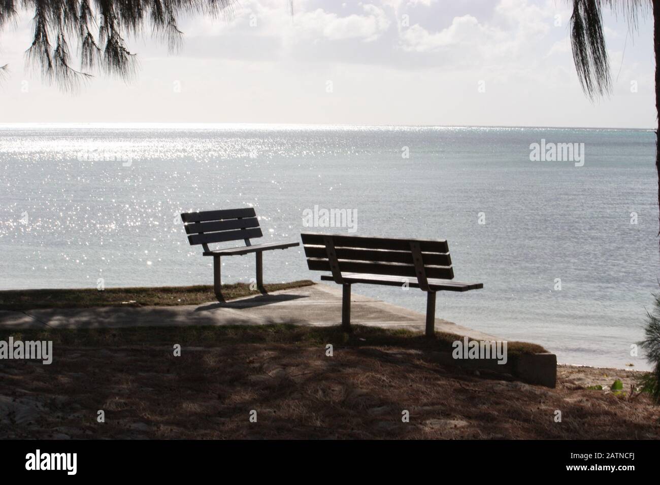 Two wooden benches facing the ocean Stock Photo - Alamy
