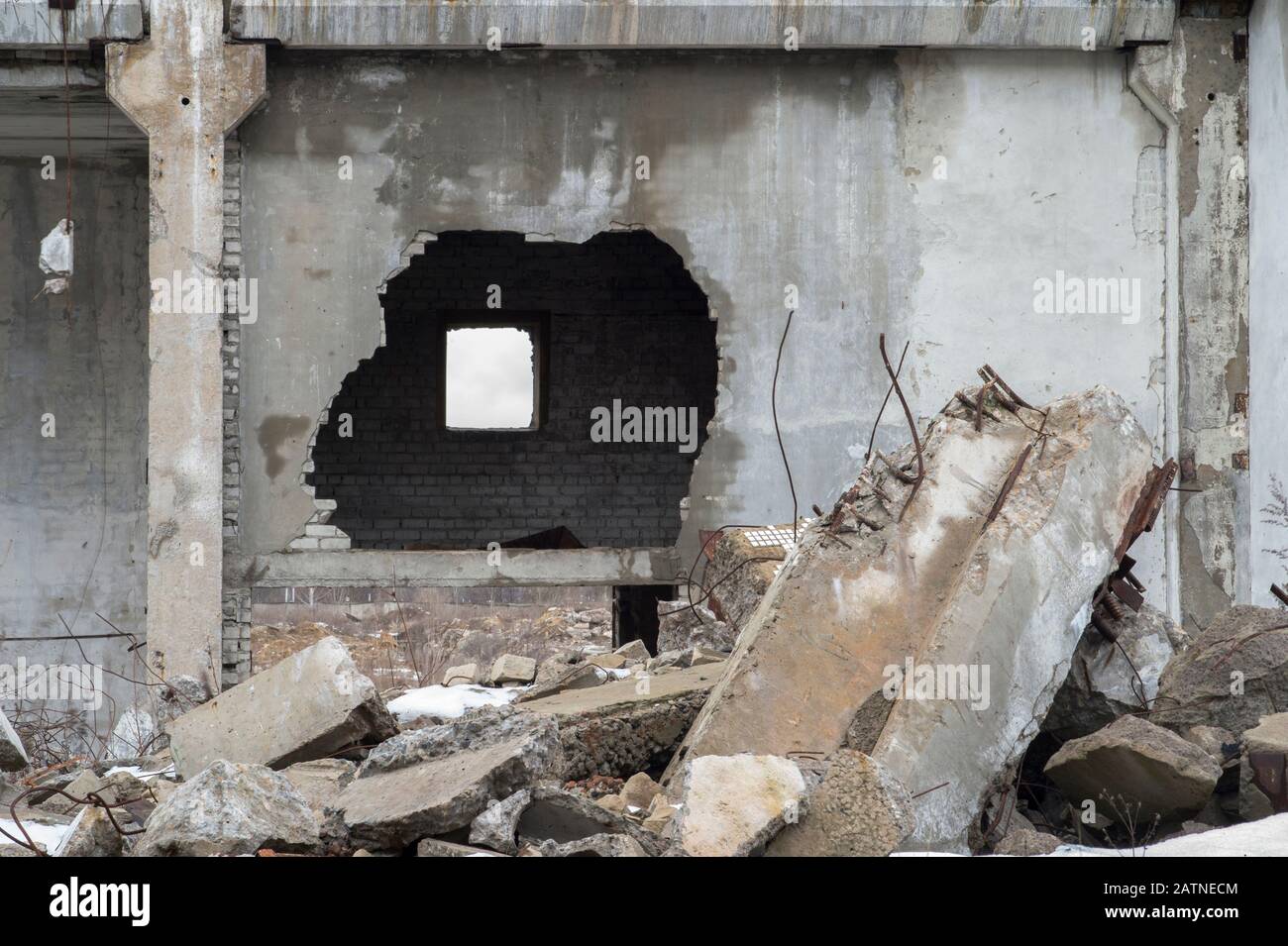 Remnants of the destruction of a large concrete building with a hole in ...