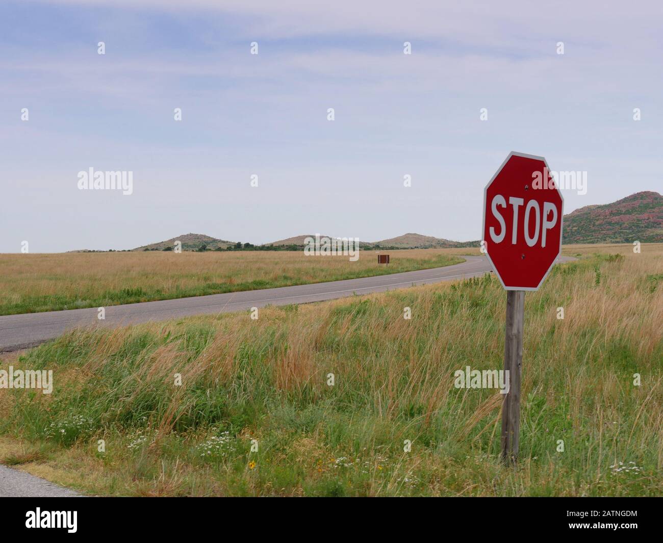 Stop sign in a meadow right by a road intersection Stock Photo - Alamy