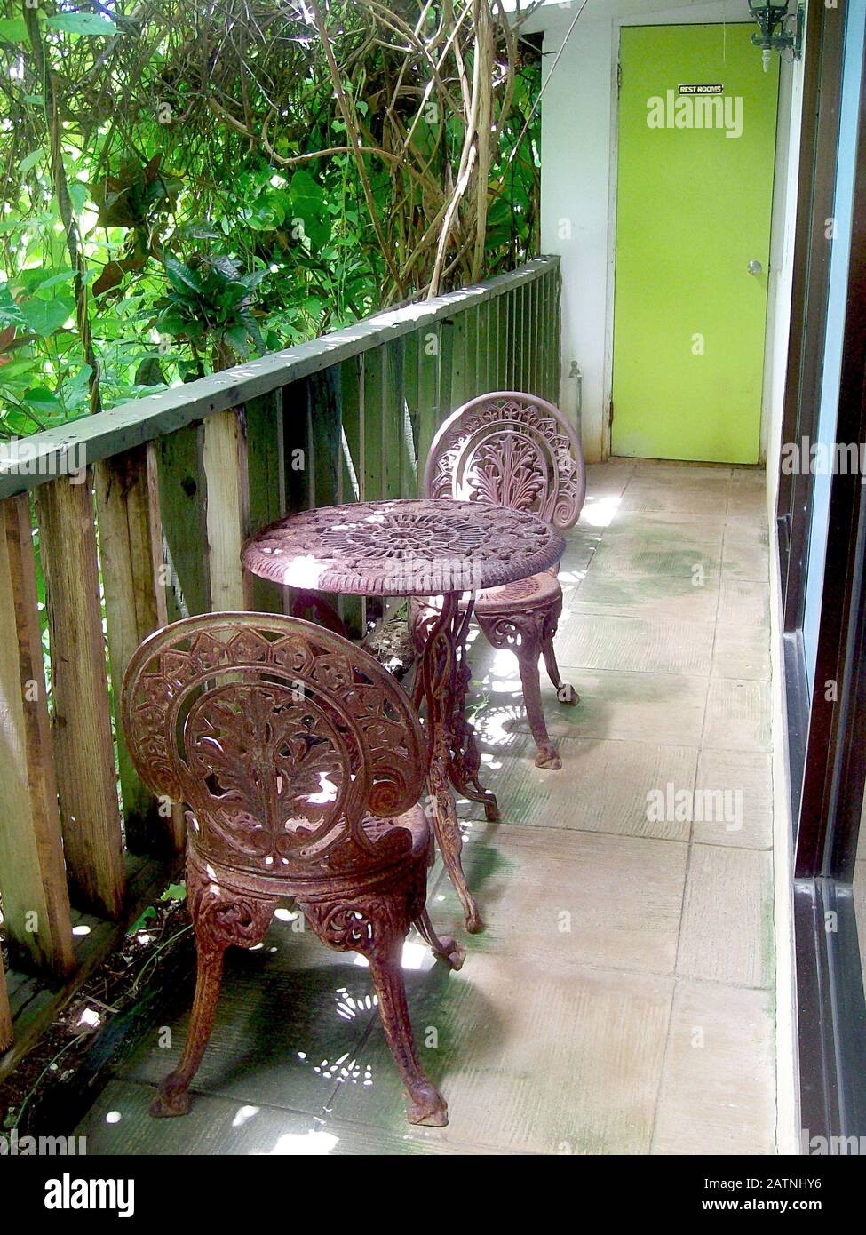 Old rusty steel table and chairs at a balcony of an abandoned building ...