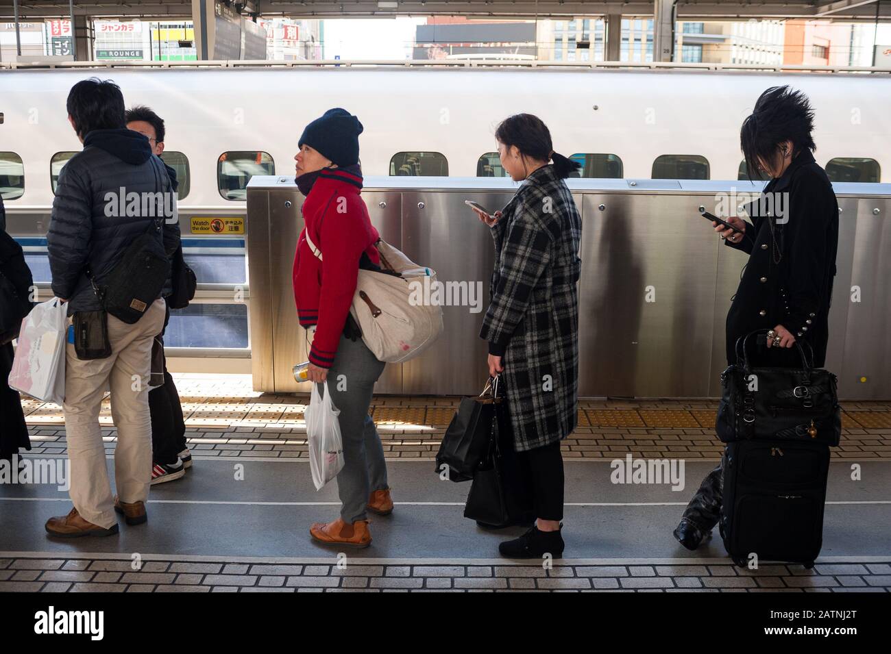 30.12.2017, Nagoya, Japan, Asia - Rail passengers wait for the Shinkansen Bullet train on a ...