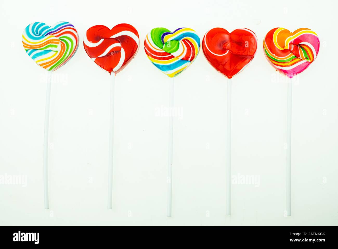 Photo beautiful Rainbow heart-shaped Lollipop candy on white background ...