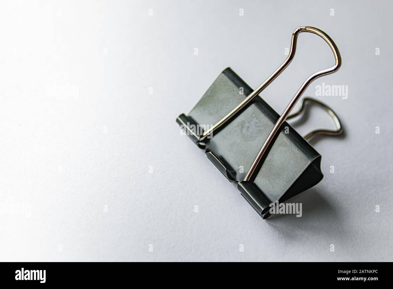 Black paper clip on white paper, clip for paper Stock Photo - Alamy