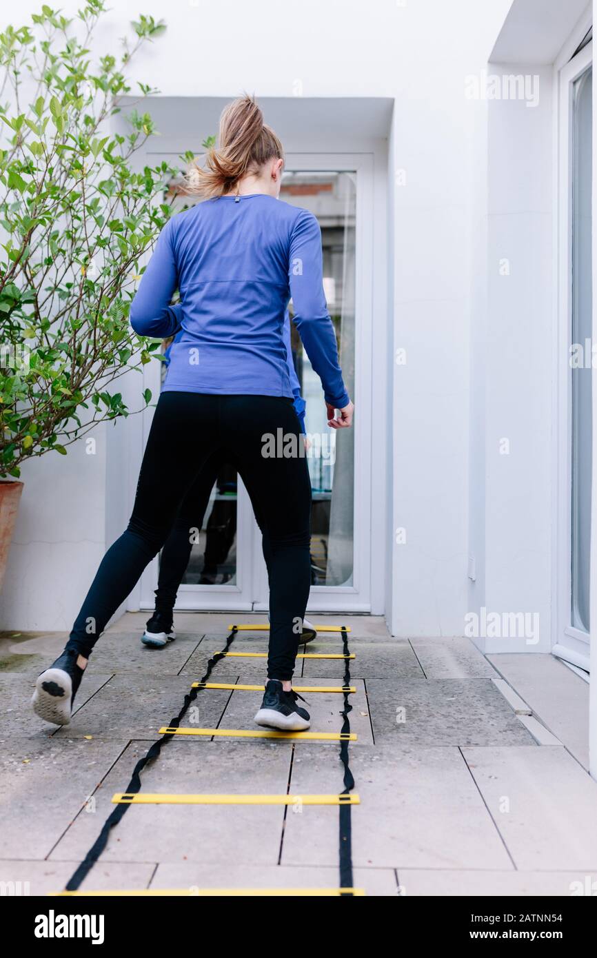 Two young women doing agility ladder exercise on a terrace Stock Photo ...