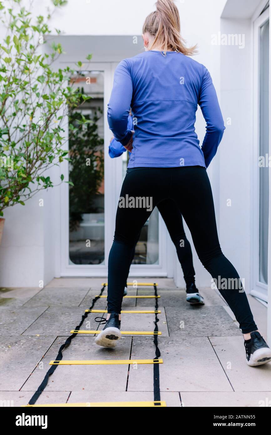 Two young women doing agility ladder exercise on a terrace Stock Photo ...