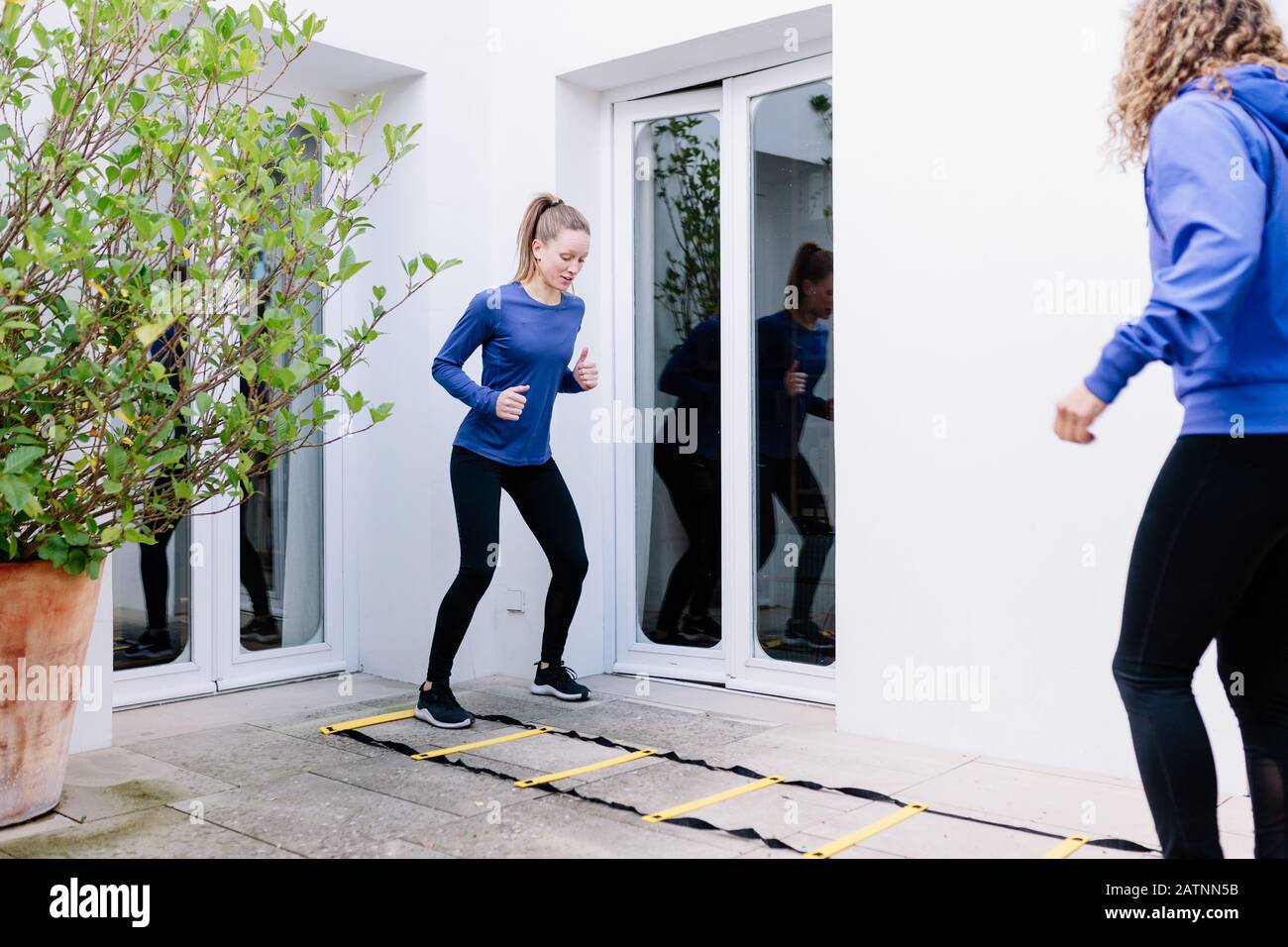 Two young women doing agility ladder exercise on a terrace Stock Photo ...