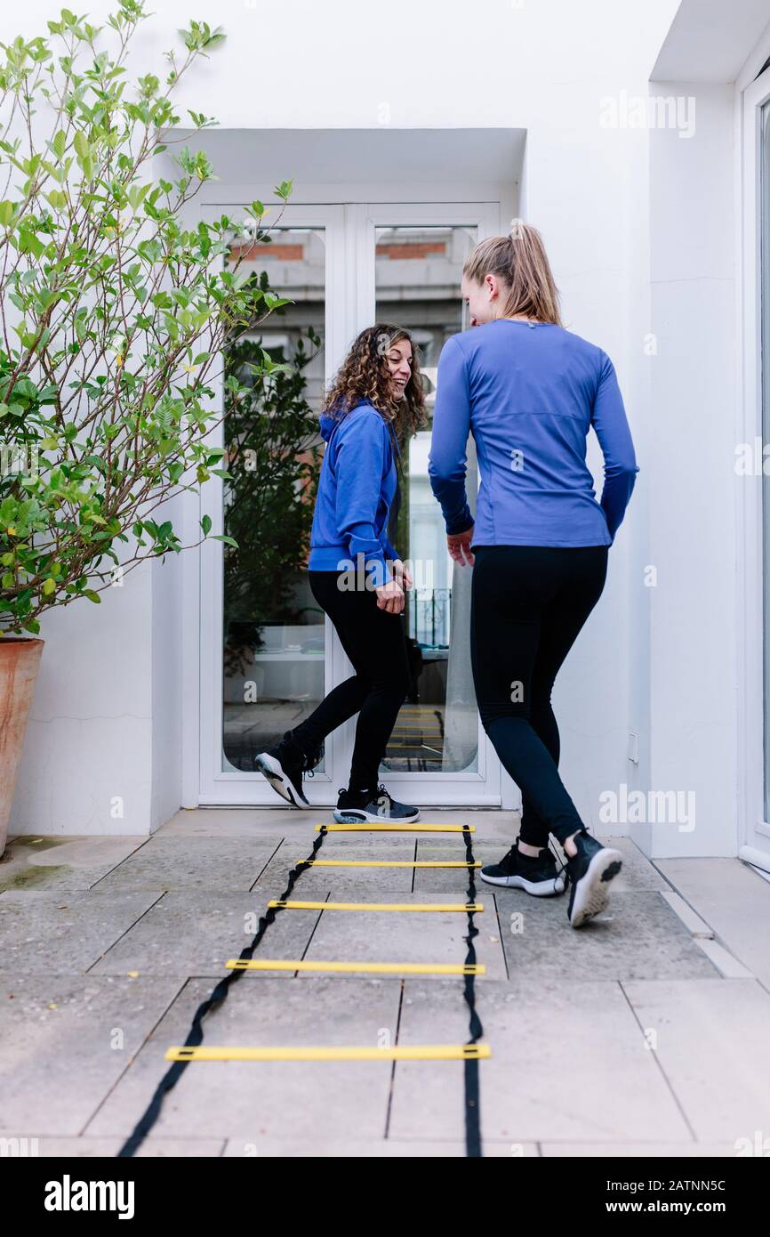 Two young women doing agility ladder exercise on a terrace Stock Photo ...
